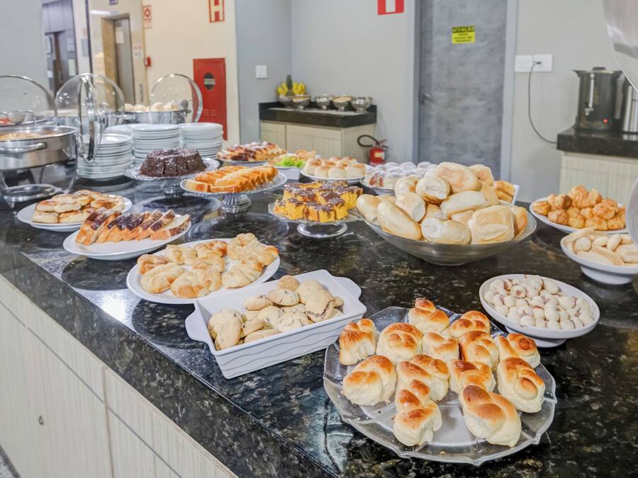 Um buffet com diversos produtos de panificação e doces.