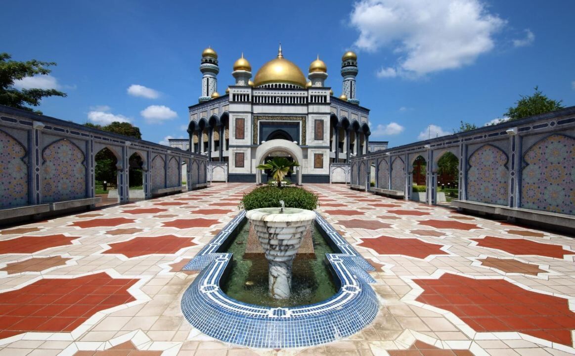 Um edifício grande e ornamentado com uma fonte central e um pátio com azulejos.