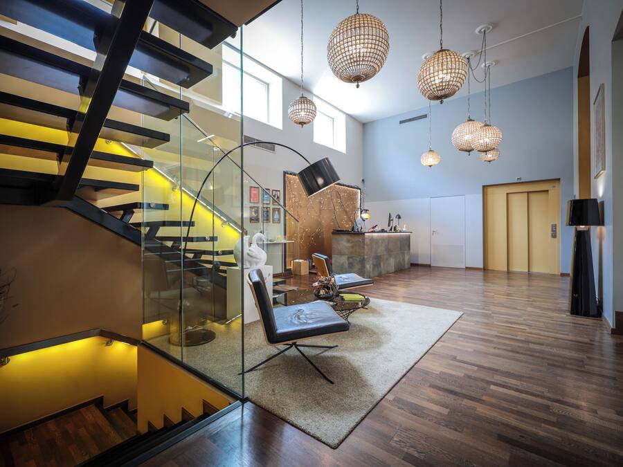 Interior moderno com escada, área de estar e luminárias pendentes.