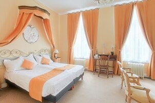 Quarto bem arrumado com uma cama, uma escrivaninha e cadeiras.