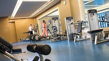 Uma academia com diversos equipamentos de ginástica, incluindo esteiras e aparelhos de musculação.