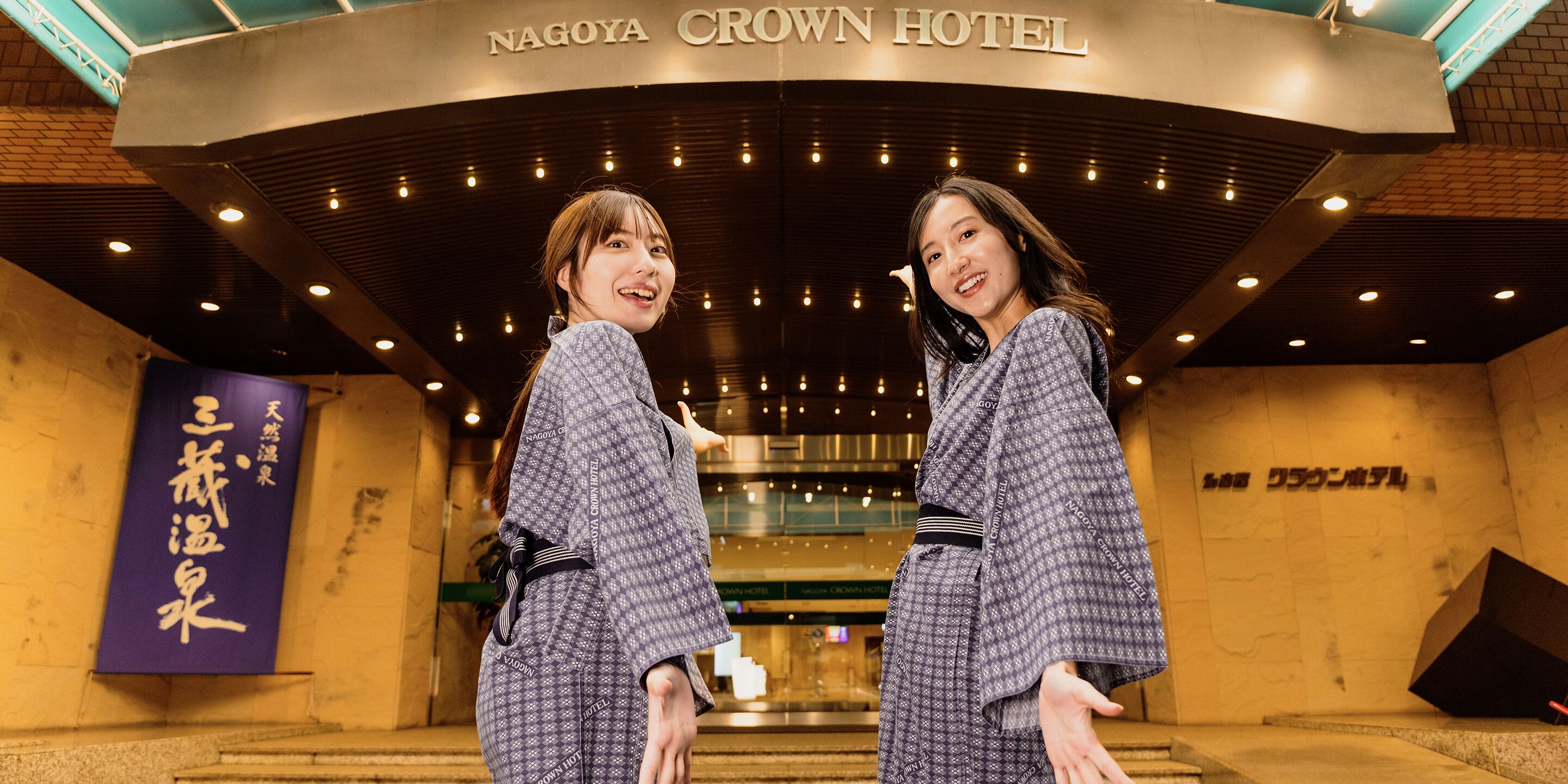 Entrada do Hotel Nagoya Crown, com design arquitetônico moderno e uma placa exibindo o nome do hotel.