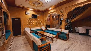 Um quarto acolhedor com sofás, uma mesa de centro de madeira e uma escada para um andar superior.