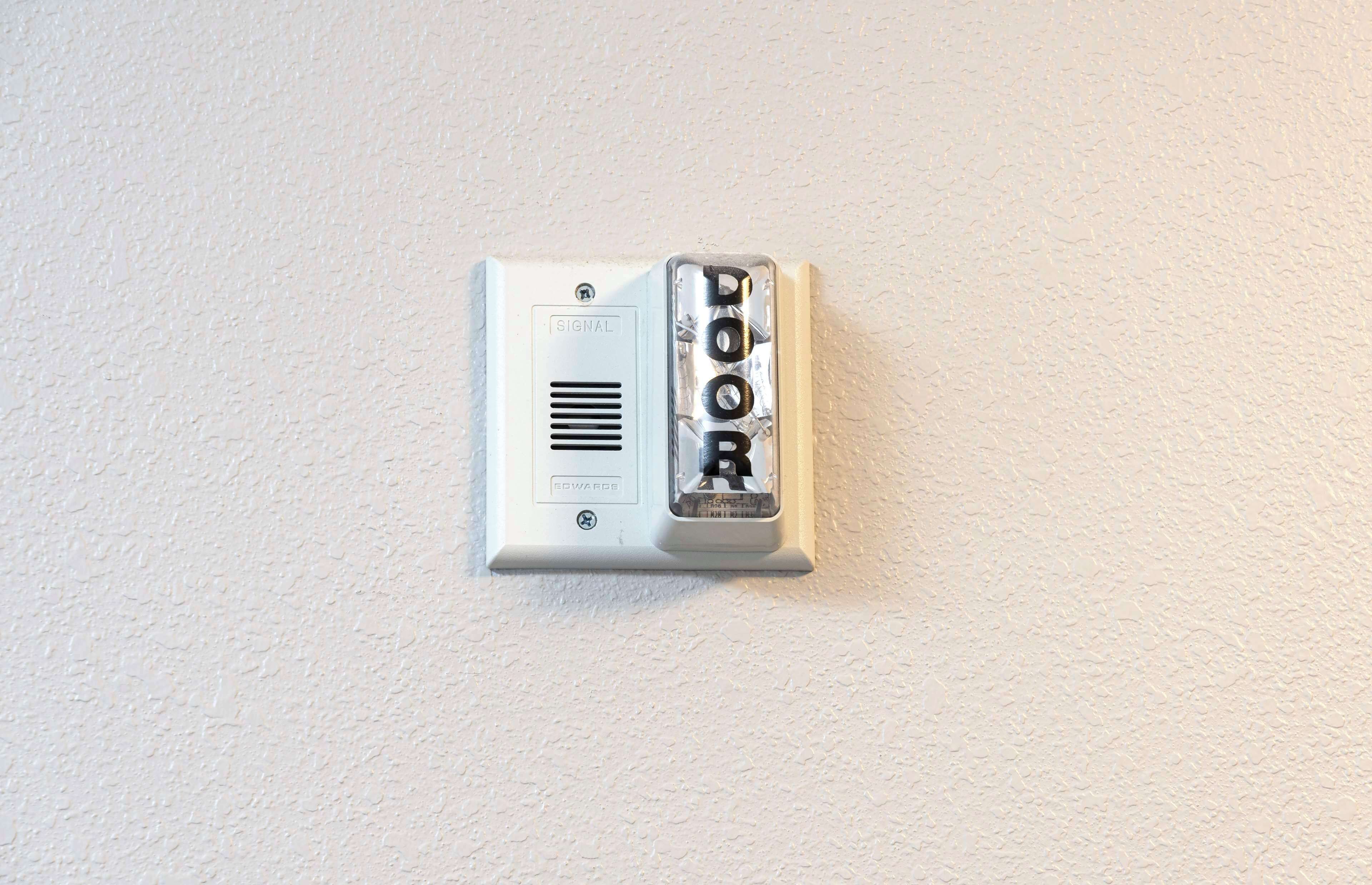 Campainha com uma placa indicando 'porta' em uma parede texturizada.