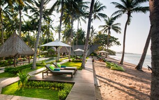 Na praia, espreguiçadeiras, guarda-sóis de praia, toalhas de praia 