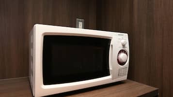 Um micro-ondas Sharp branco com visor digital e botão de energia sobre uma bancada de madeira.