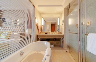 Uma casa de banho moderna com uma banheira grande, um lavatório com espelho e uma área de duche.