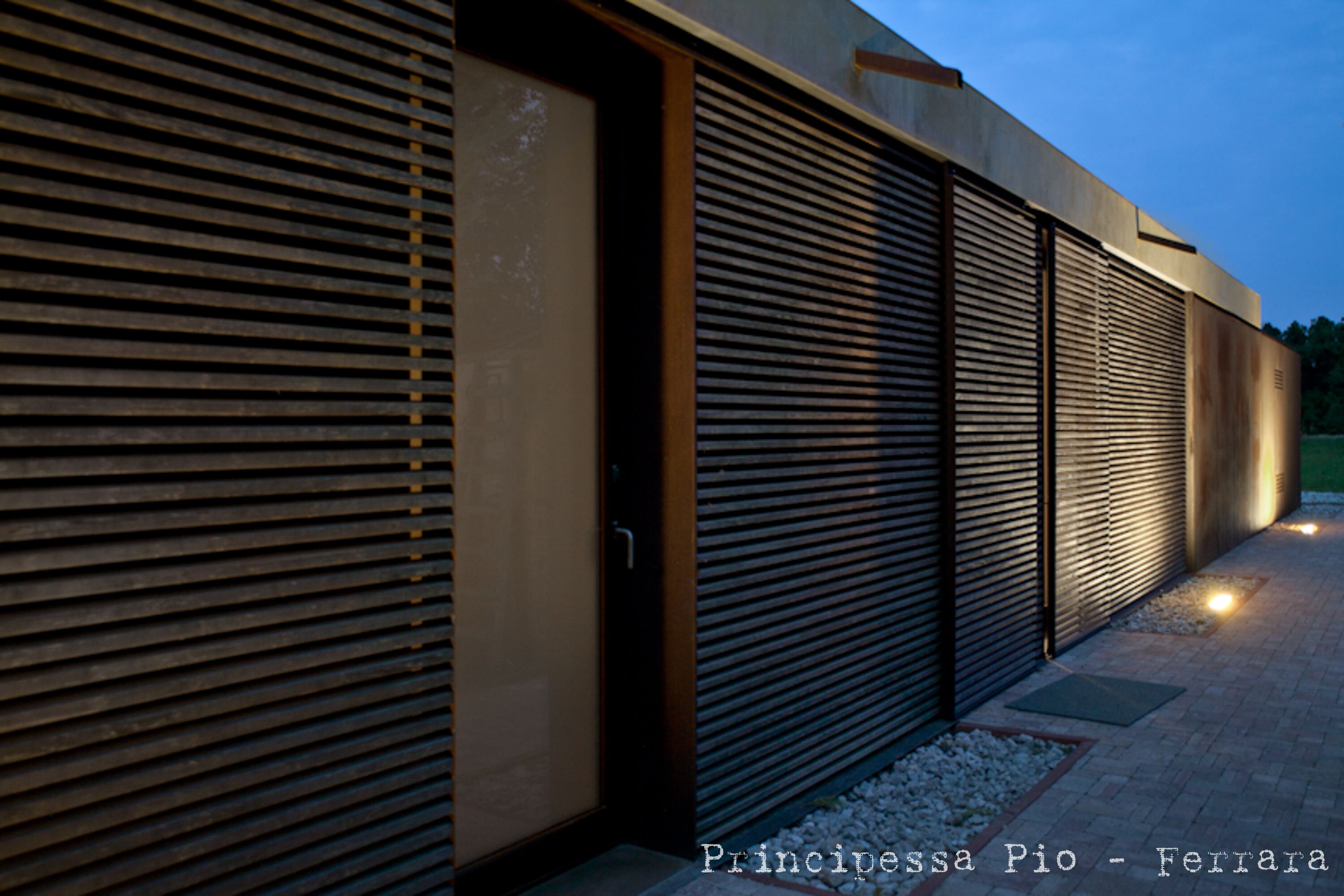 Um edifício moderno com paredes externas de ripas horizontais e uma porta.