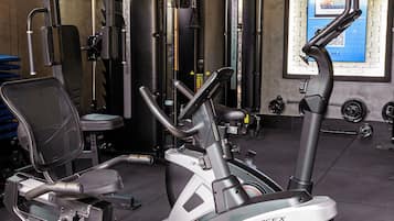 Uma academia com equipamentos de ginástica, incluindo uma bicicleta ergométrica e aparelhos de musculação.