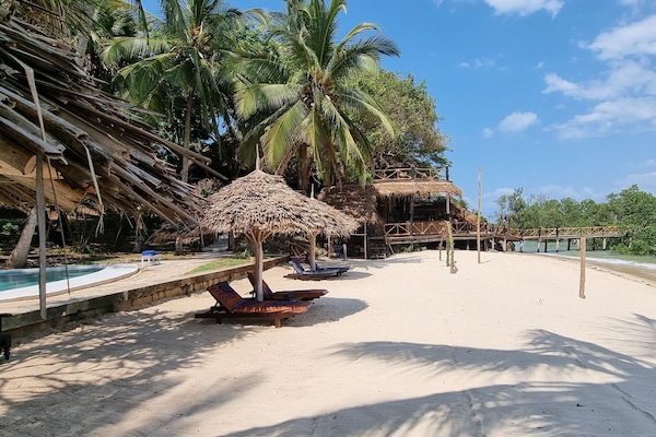 Na praia, espreguiçadeiras, guarda-sóis de praia, toalhas de praia