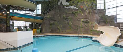 Piscina interna com toboáguas e um mural de uma cascata.