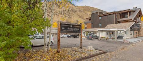 Placa da Miller Park Lodge com vista para o edifício e carros estacionados.
