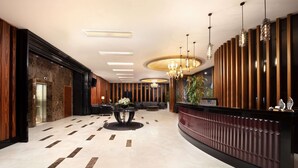 Um hall amplo com balcão de recepção, área de estar e um lustre.