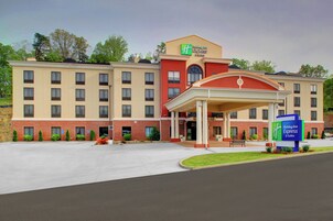 Um hotel Holiday Inn Express & Suites com entrada coberta, várias janelas e fachada de tijolos.