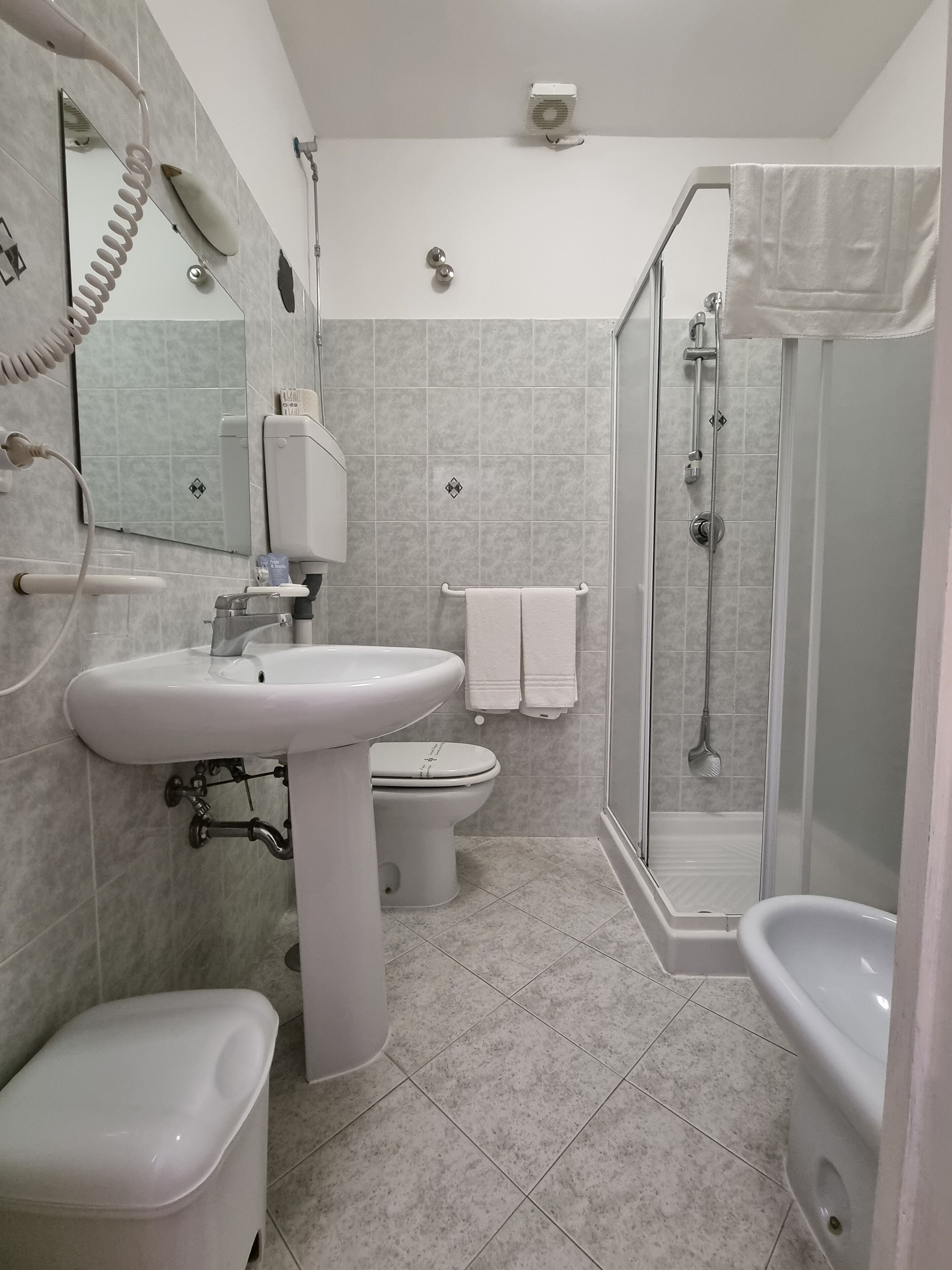 Casa de banho com lavatório, sanita e chuveiro.