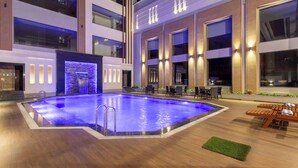 Um hotel moderno com piscina, área de estar ao ar livre e uma cascata.