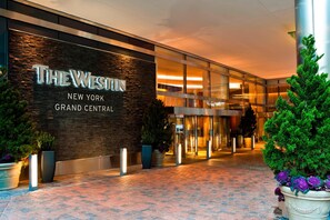 Fachada do edifício Westin New York Grand Central, com parede de pedra e entrada de vidro.