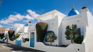 Um edifício branco com detalhes em azul e um céu azul límpido.