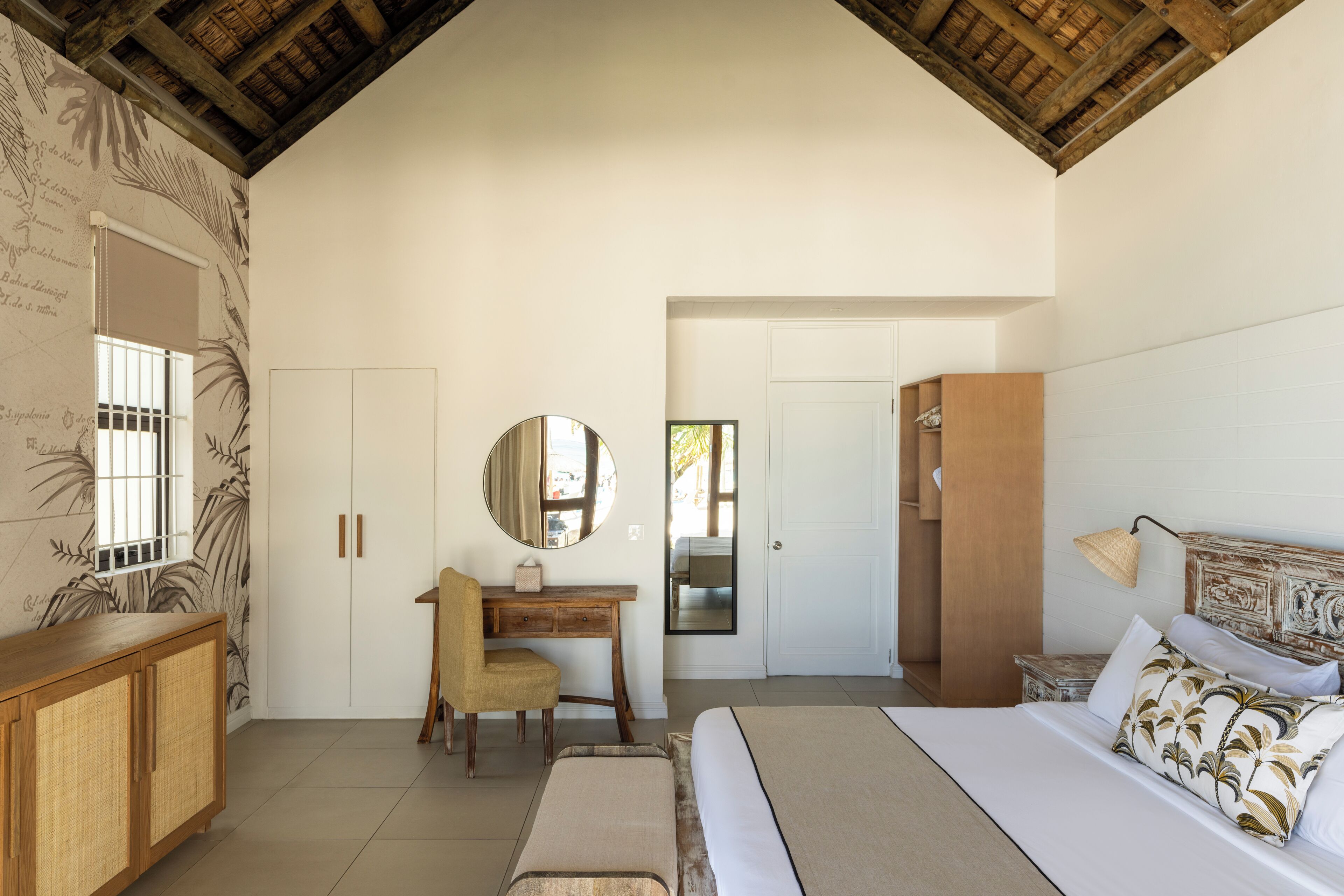 Quarto com cama, escrivaninha, cadeira, guarda-roupa e espelho.
