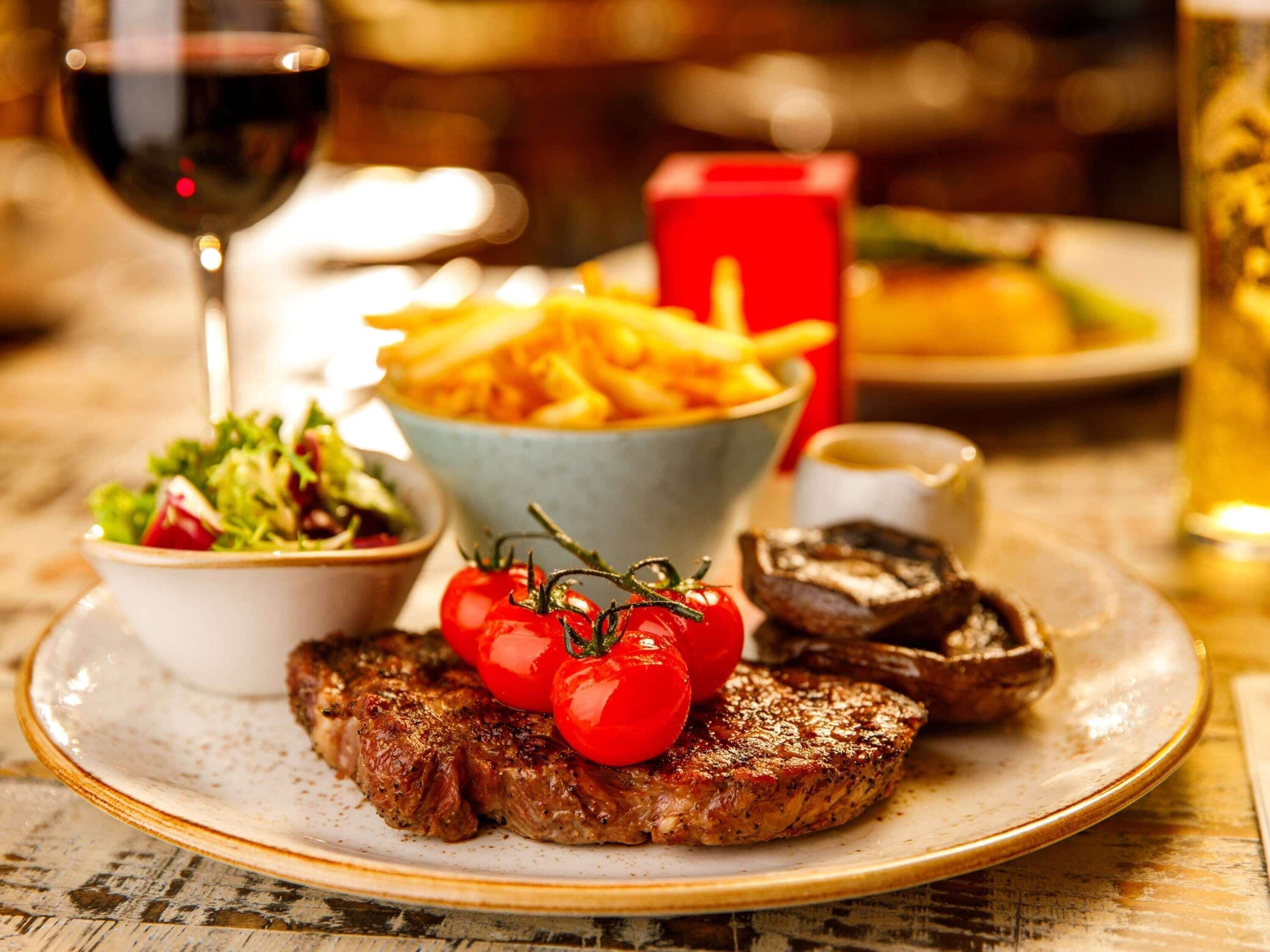 Prato com bife, tomate, batatas fritas e salada.