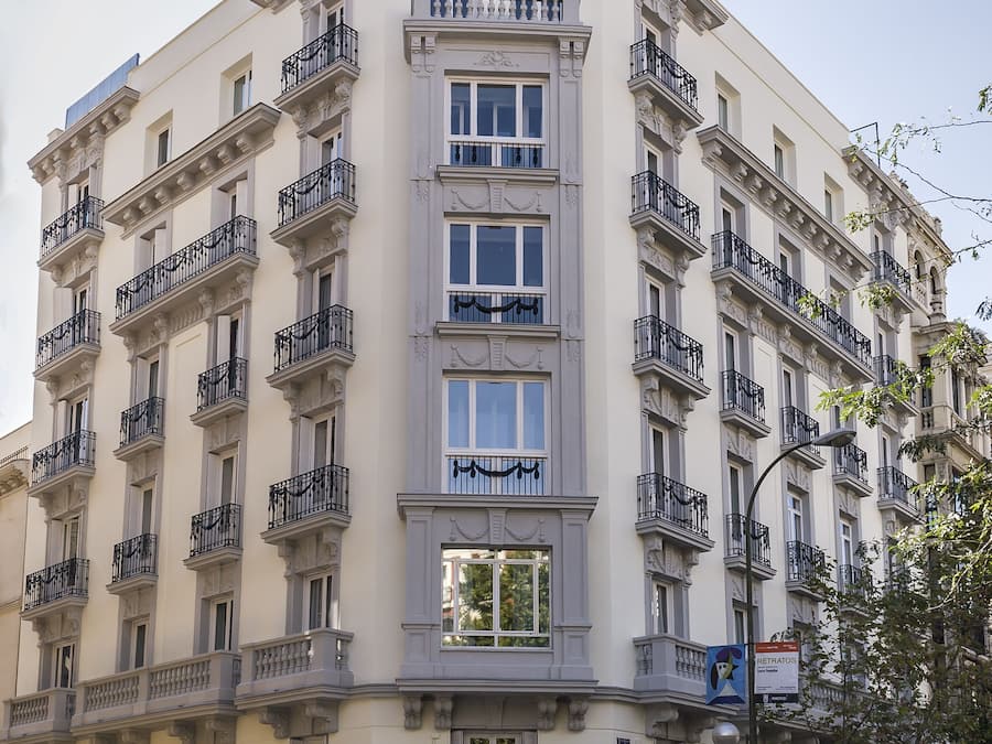 Um edifício de vários andares com estilo arquitetônico clássico, apresentando varandas e grandes janelas.