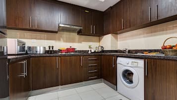 Um frigorífico/congelador grande, um micro-ondas, uma cafeteira/bule