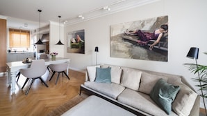 Uma sala de estar moderna com sofá, poltronas e obras de arte nas paredes.