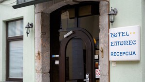 Entrada de hotel com uma placa que diz 'HOTEL EMOREC RECEPCIA'.