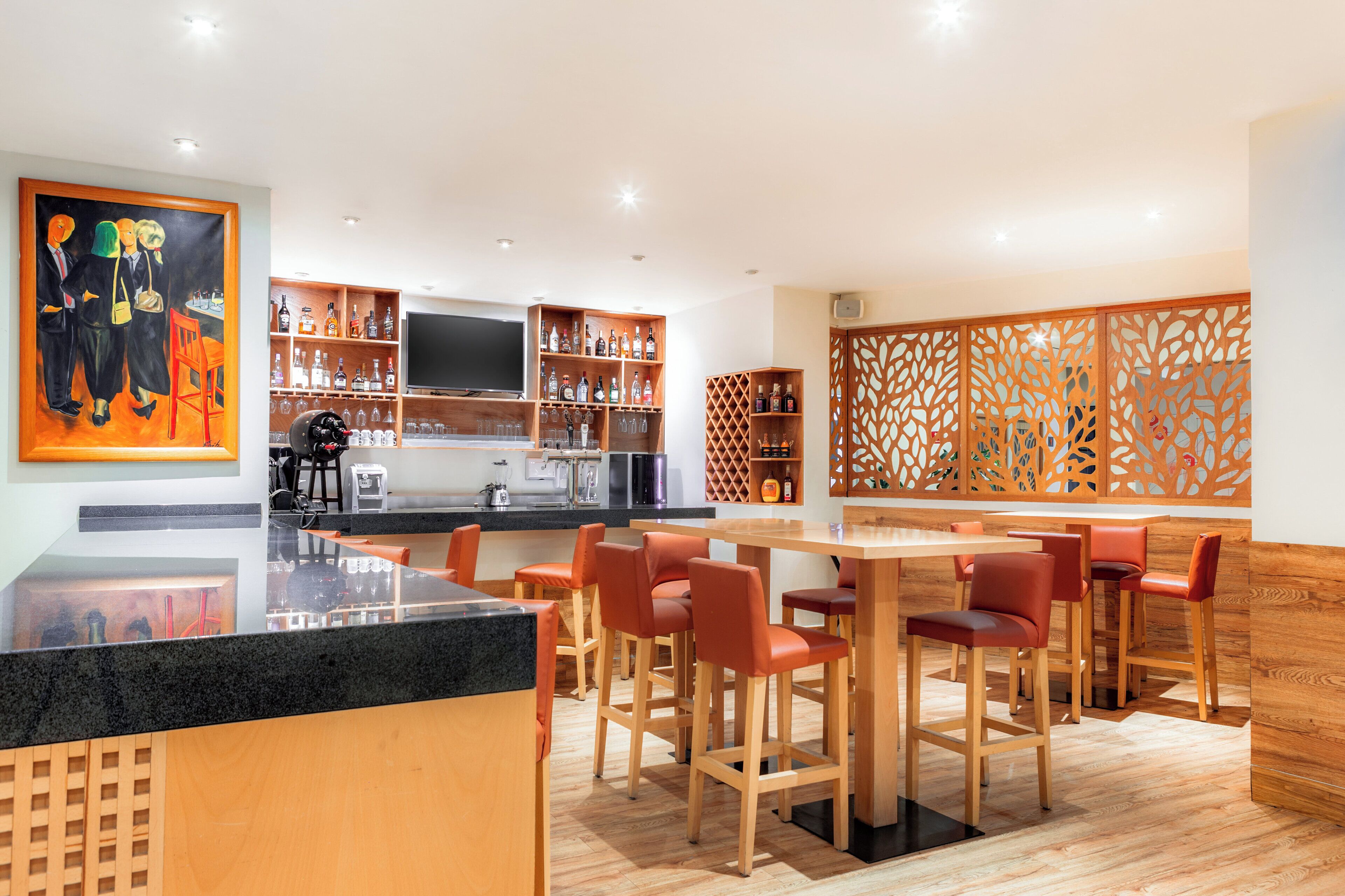 Cozinha moderna com área de bar, móveis de madeira e um painel decorativo.