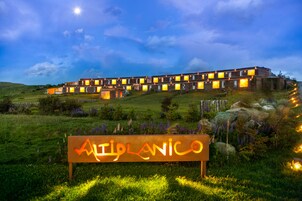 Um hotel com uma fileira de quartos iluminados sob o céu crepuscular.