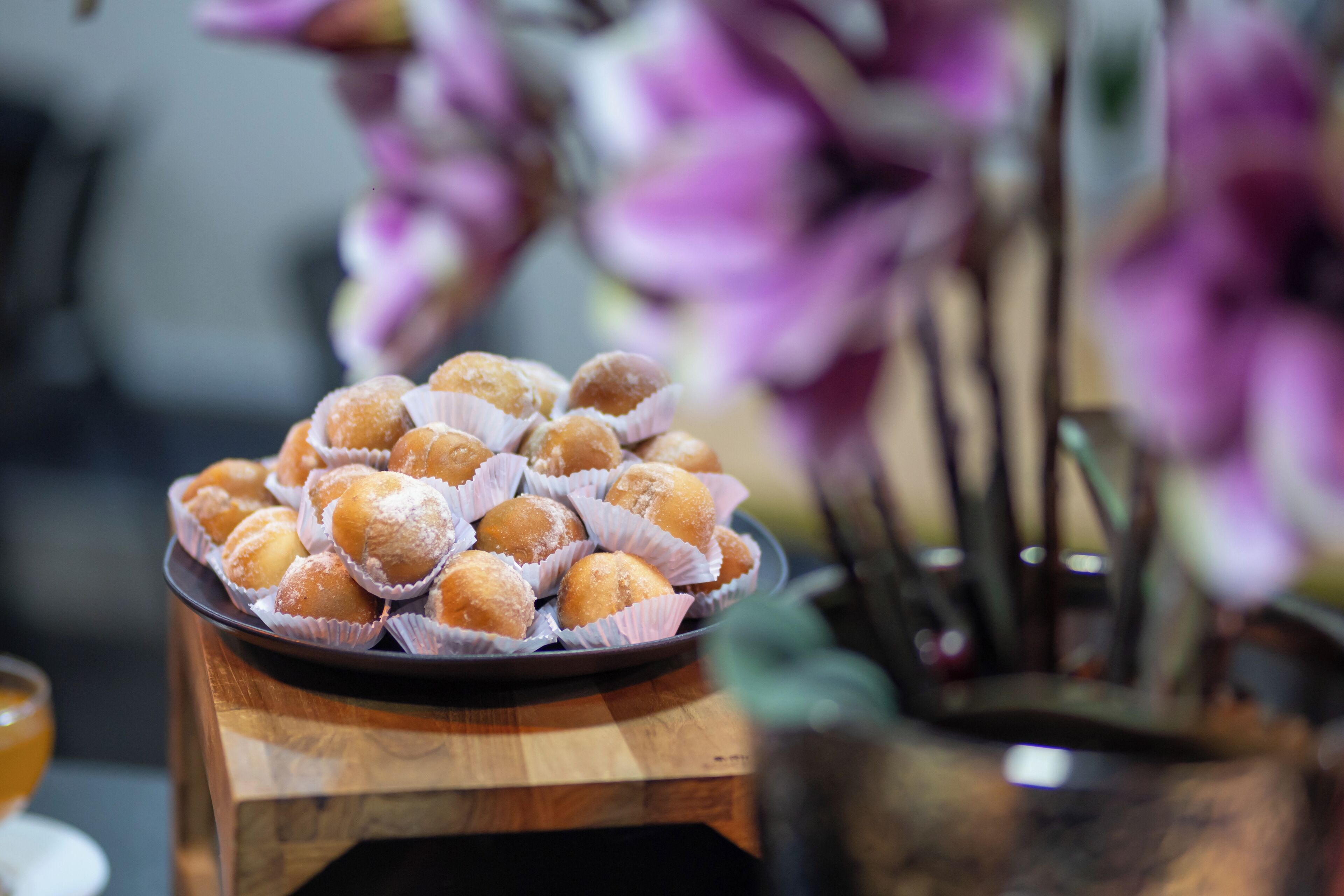 Uma travessa de doces redondos sobre um suporte de madeira.
