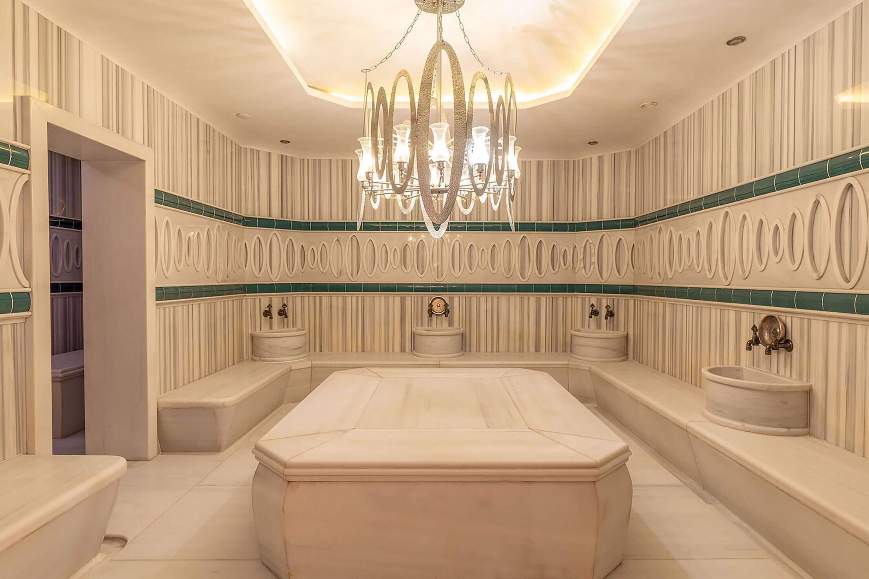 Um banheiro luxuoso com uma banheira grande, duas pias e um candelabro.