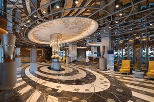 Um lobby com área circular central, um lustre e disposição de assentos.