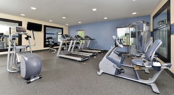 Academia com esteiras, elípticos e equipamentos de musculação.