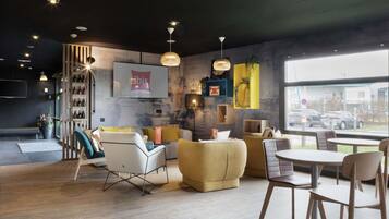 Um interior moderno com sofás, uma mesa de centro e uma TV fixada na parede.