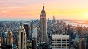 Paisagem urbana com um arranha-céu imponente, provavelmente o Empire State Building, cercado por outros edifícios altos.