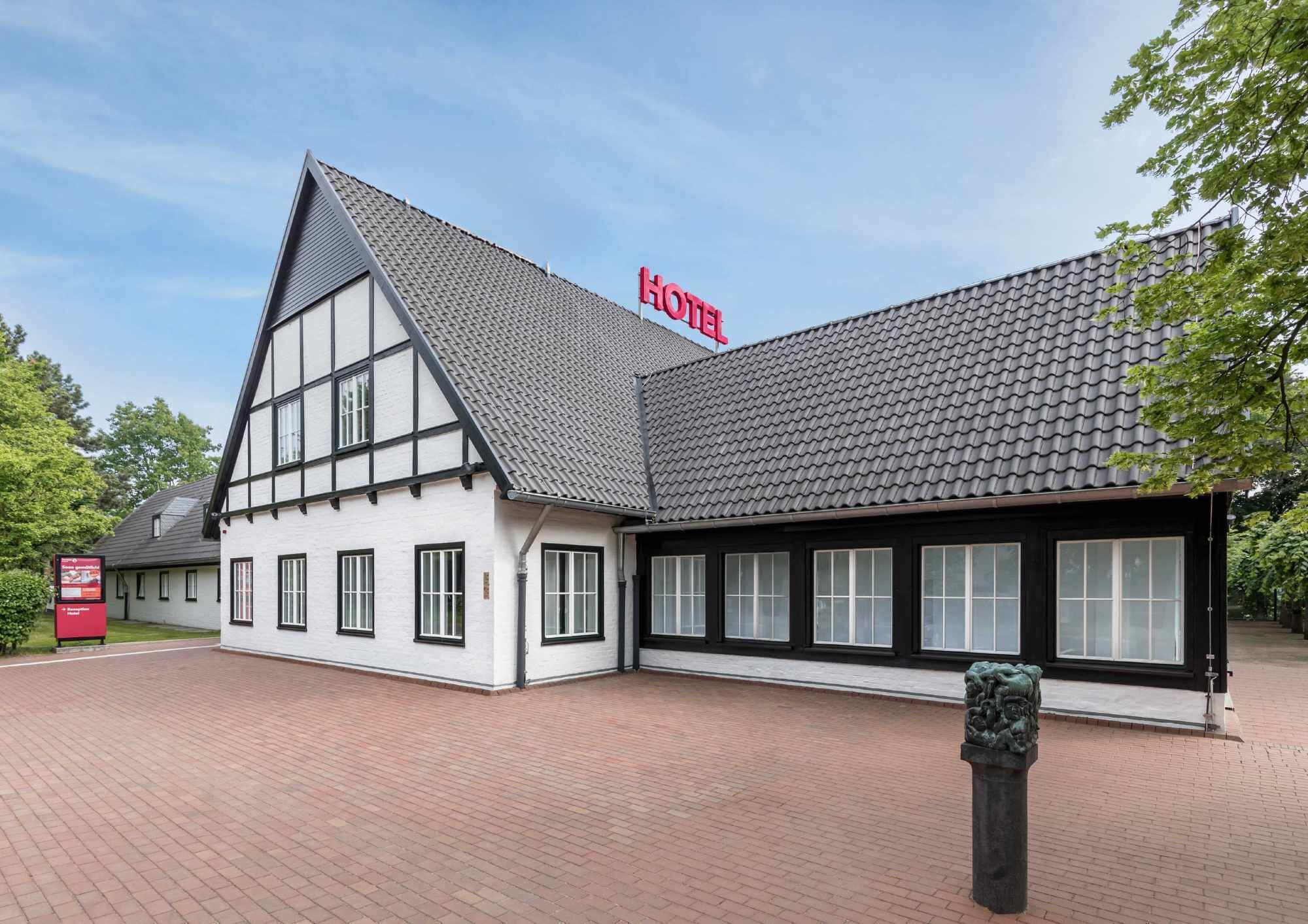 Um edifício tradicional com telhado inclinado e um letreiro chamativo com a palavra 'HOTEL'.