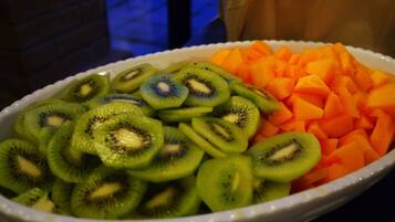 Uma tigela com kiwi fatiado e manga em cubos.