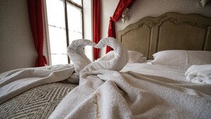 Quarto de hotel com cama, cortinas vermelhas e cabeceira.