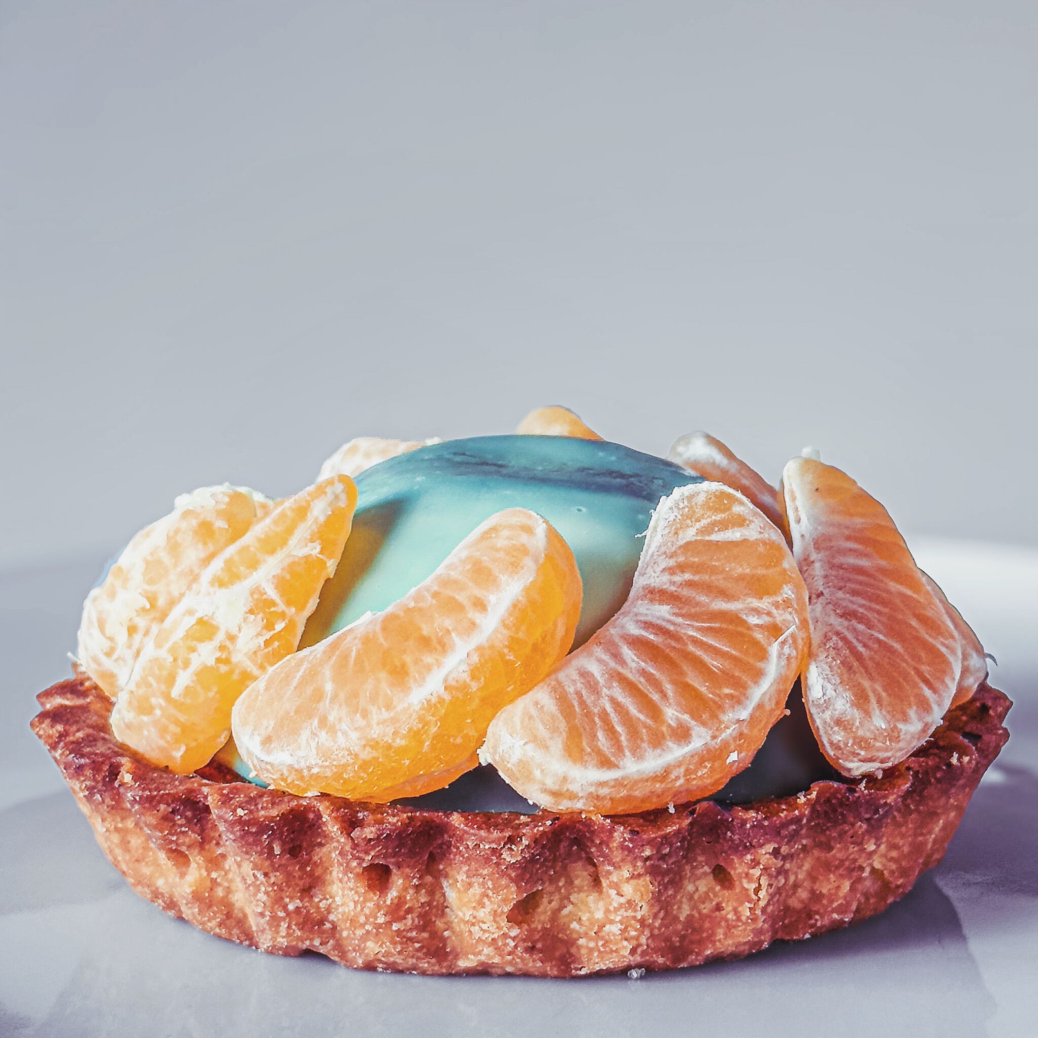 Uma torta com cobertura brilhante e fatias de laranja sobre a base.
