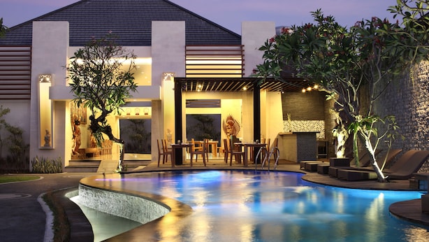 Uma casa moderna com piscina, área de jantar externa e interior bem iluminado.