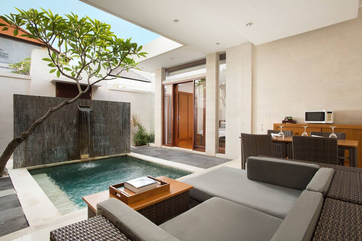 Uma área externa moderna com piscina, assentos e espaço para refeições.