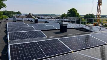 Painéis solares no telhado com vista ampla da paisagem ao redor.