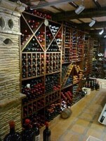 Uma adega com prateleiras de madeira repletas de garrafas de vinho.