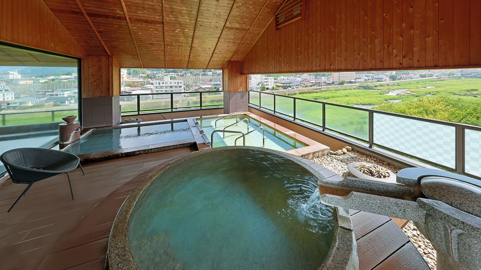 Interior em madeira com banheira de hidromassagem e vista para a cidade.