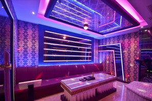 Uma sala de estar moderna com um sofá vermelho, uma mesa de centro de vidro e iluminação neon.