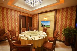 Uma sala de jantar com uma mesa redonda posta para seis pessoas, cercada por seis cadeiras.