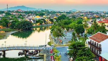 Uma cidade ribeirinha com uma ponte, barcos e edifícios ao longo da água.