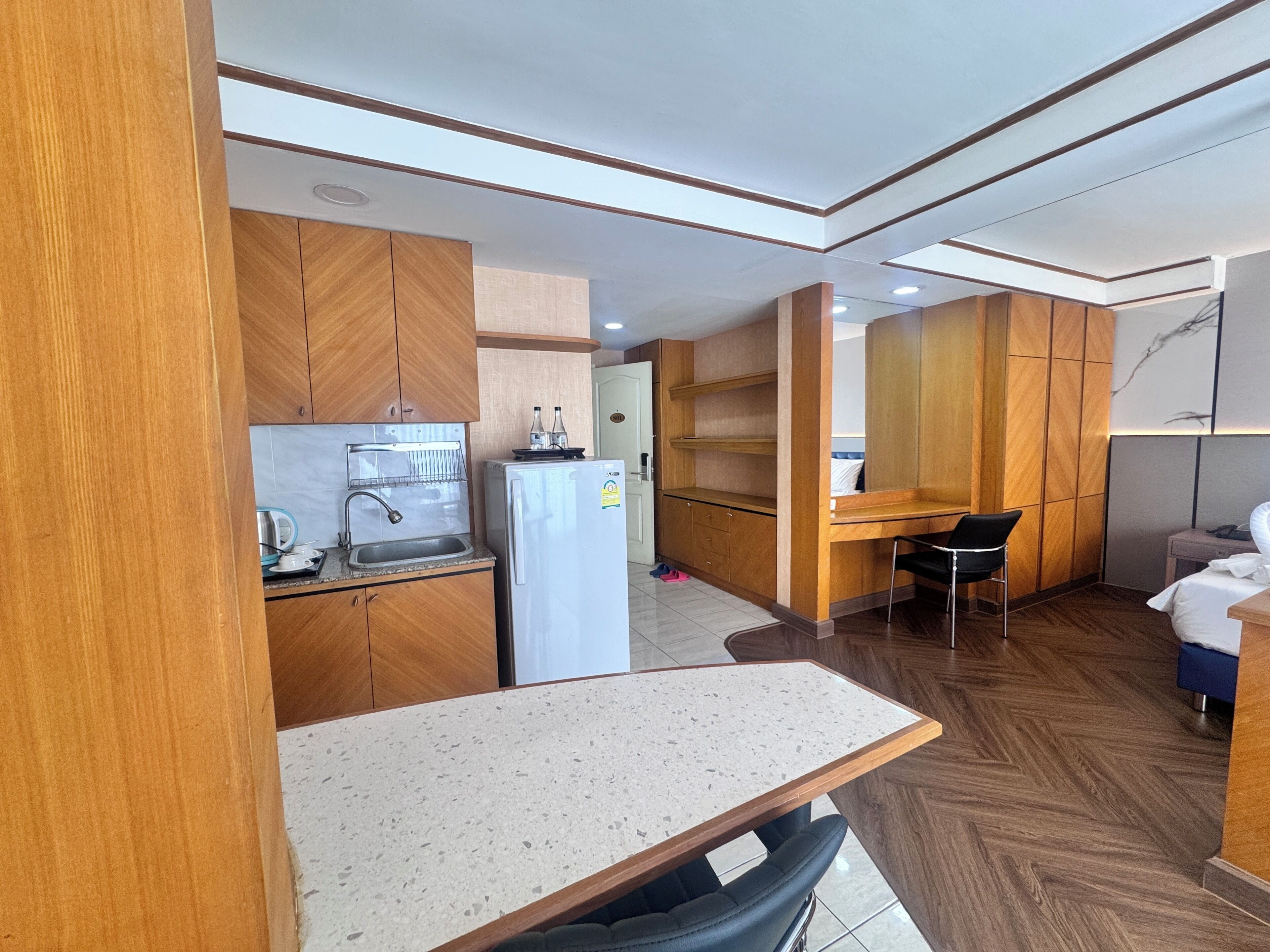 Quarto de hotel compacto com cozinha compacta, área de refeições e cama.