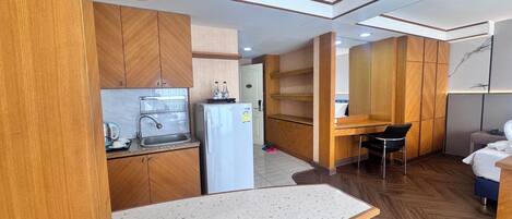 Quarto de hotel compacto com cozinha compacta, área de refeições e cama.